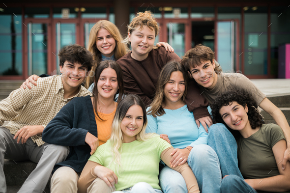 Delighted young friends cuddling and smiling at camera on street Stock ...