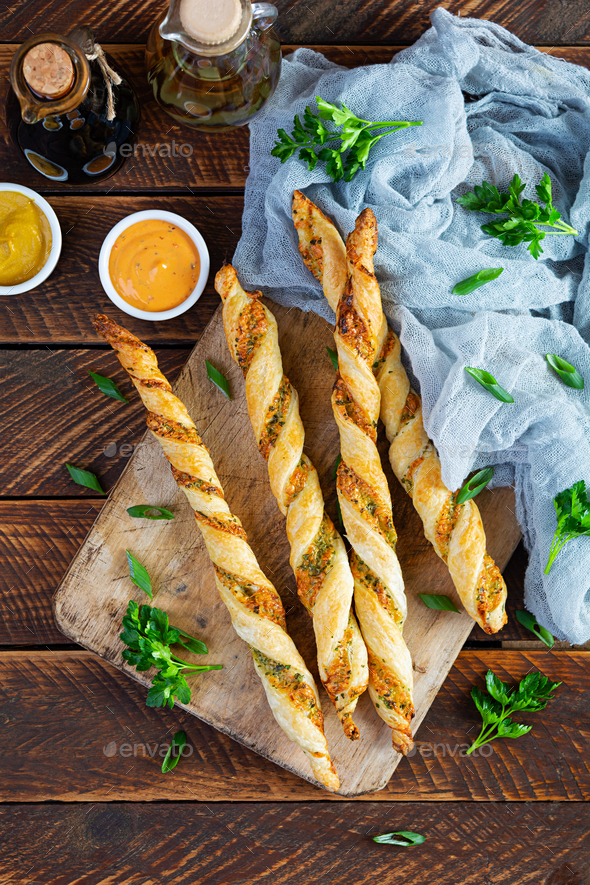 Puff sticks with cheese and herbs. Homemade breadsticks with sauce ...