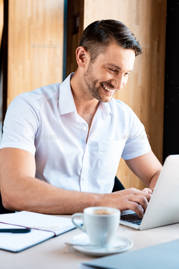 smiling freelancer typing on laptop keyboard in cafe Stock Photo by ...