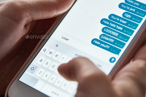 partial view of abuser sending offensive messages while using ...