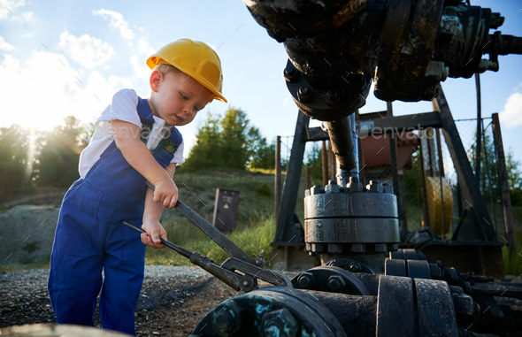 Boy with instrument fixing drilling rig Stock Photo by anatoliy_gleb