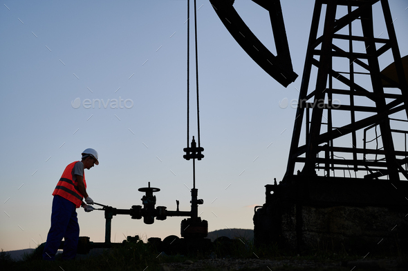 Oil man using petroleum pump jack in oil field. Stock Photo by anatoliy ...