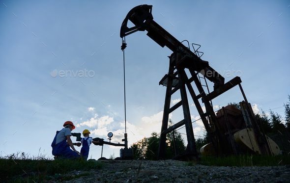 Oilman and little boy in work uniform at petroleum drilling rig. Stock ...