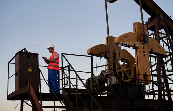 Mechanic recording performance of operation oil rig. Stock Photo by ...