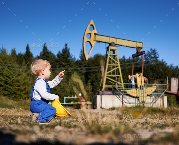 Little kid boy pointing finger at oil rig. Stock Photo by anatoliy_gleb