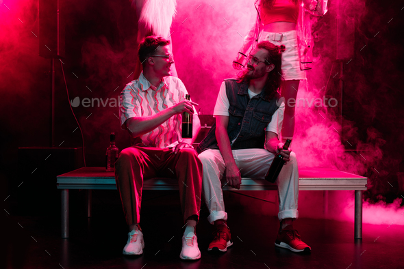 men sitting with beer and talking in nightclub during rave Stock Photo ...