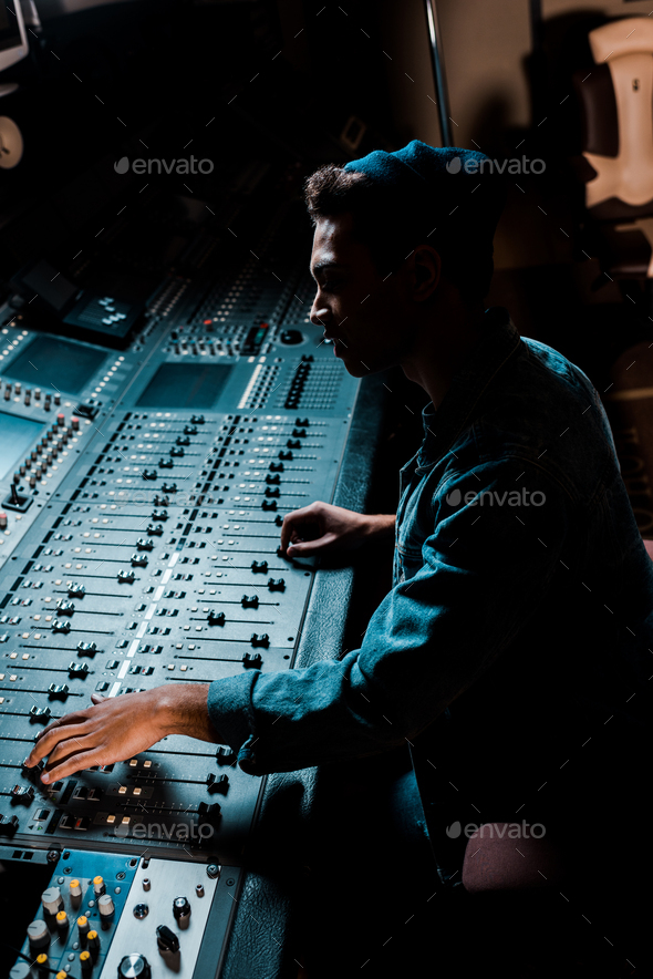 sound producer working at mixing console in dark recording studio Stock ...