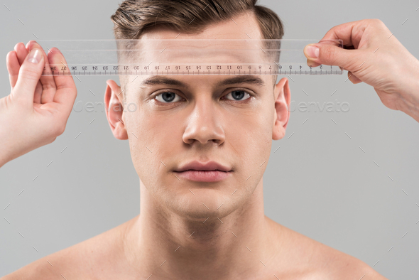 partial view of plastic surgeons measuring face with ruler isolated on ...