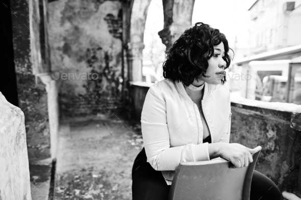 Stylish african american plus size model sitting on red chair outdoor ...