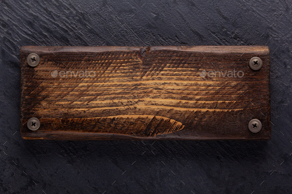 Wooden nameplate or sign board screwed at wall background. Front view ...