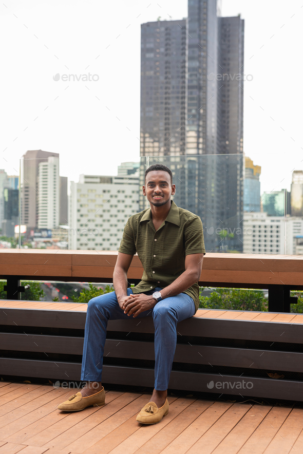 Portrait of handsome young black man outdoors in city Stock Photo by ...