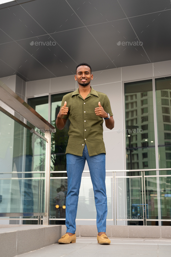 Portrait of handsome young black man outdoors in city Stock Photo by ...