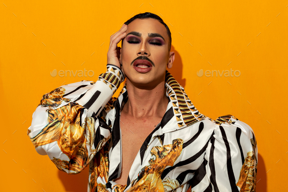 Portrait of drag queen with fashionable mustache yellow background ...