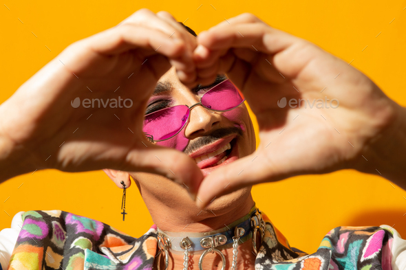 portrait of young drag queen smiling through her hands forming a heart ...