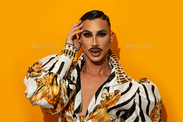 Portrait of drag queen with fashionable mustache yellow background ...