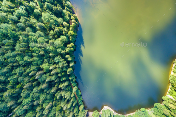 Top down aerial view of big lake with clear blue water between high ...