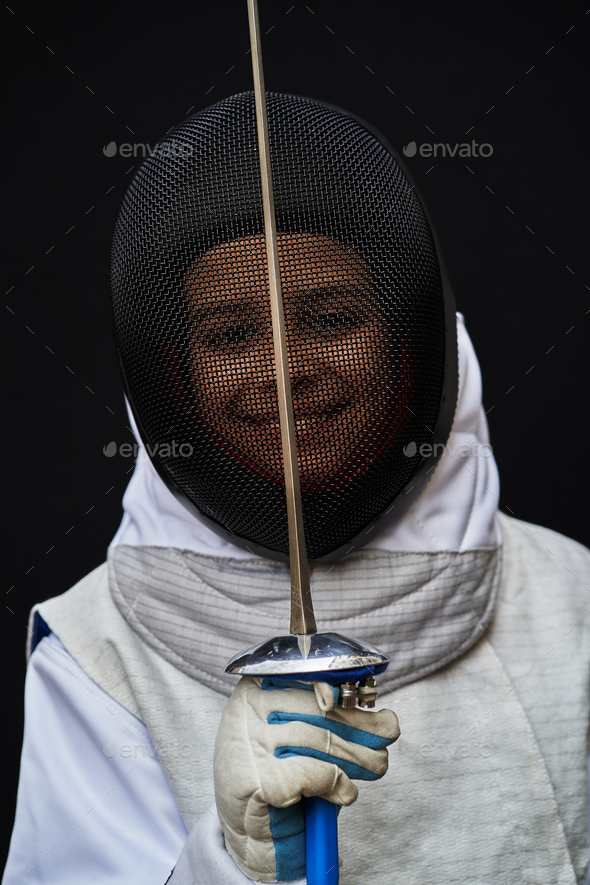 Portrait of boy dressed in fencing costume on black background. Stock ...