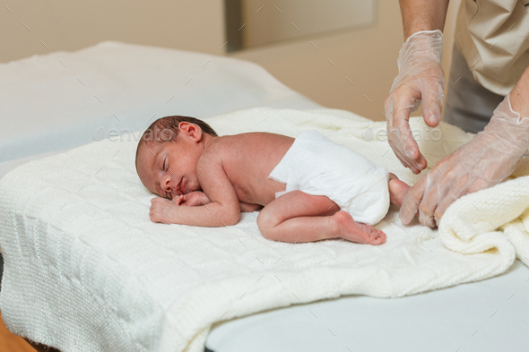 Physiotherapist performing a pro-decubitus roll over a newborn baby ...