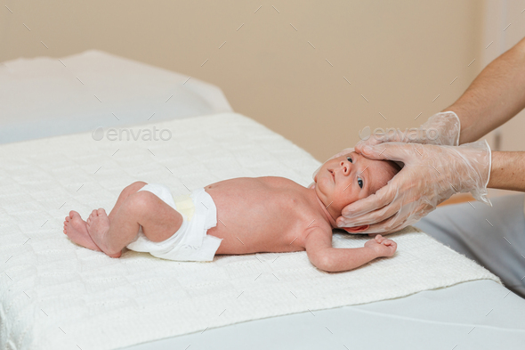 Physiotherapist performing a metopic suture work on a newborn baby in a ...