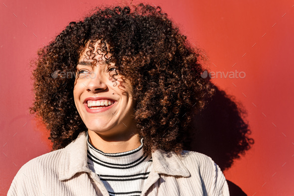 smiling black woman on a red background Stock Photo by Raul_Mellado