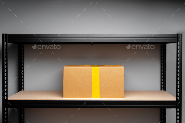 Stand shelf with one packed cardboard box Stock Photo by FabrikaPhoto