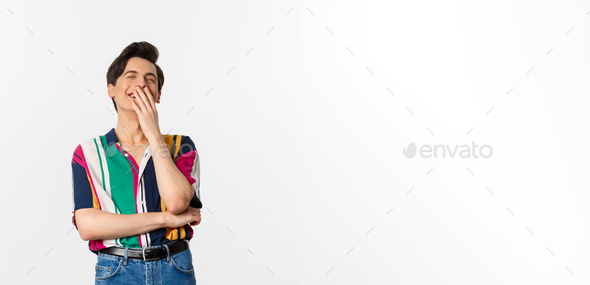 Image of handsome young man laughing over joke, having fun, cover mouth ...