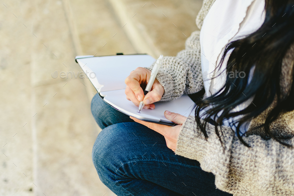 Woman's hand taking notes in her notebook with pen, sitting. Stock ...
