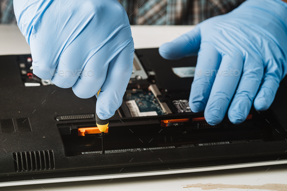 Man using a screwdriver to disassemble a computer for maintenance Stock ...