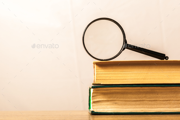 books and magnifying glass Stock Photo by FabrikaPhoto | PhotoDune