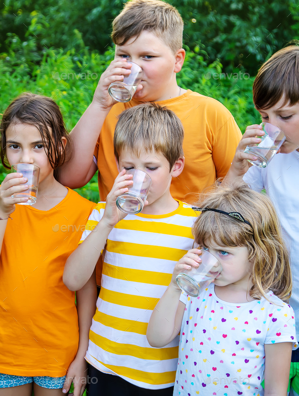Children drink water outside together. Selective focus. Stock Photo by ...