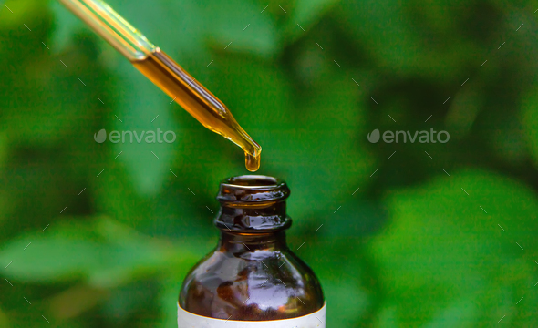 Essential oil extract of medicinal herbs in a small bottle. Selective ...