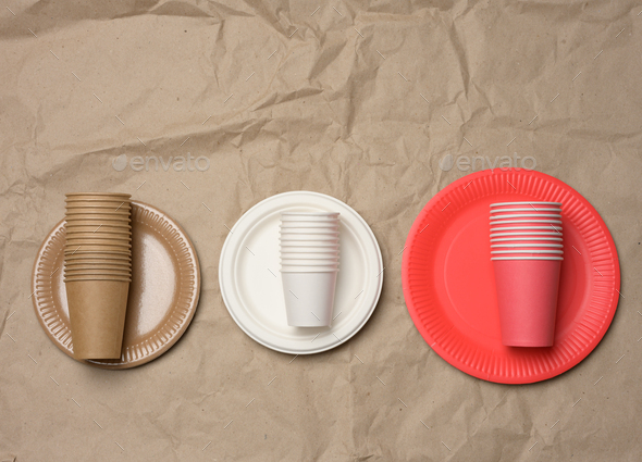 Stack of paper cups and round plates on a brown paper background Stock ...