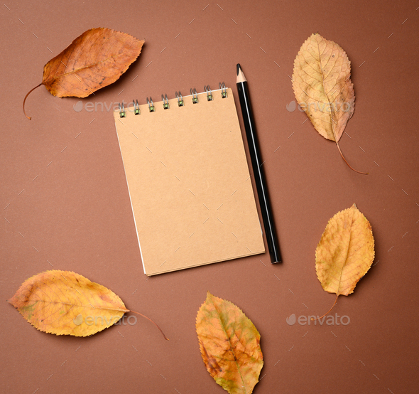 Notepad with empty brown sheets on a brown background Stock Photo by ndanko