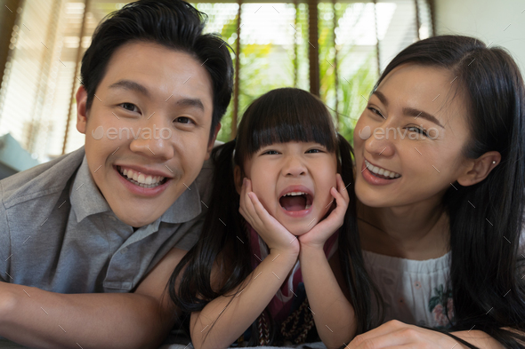 Portrait of happy asian family spending time together in living room ...