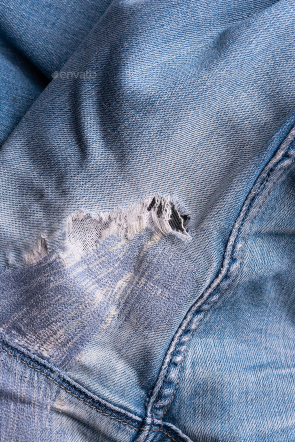 Closeup of torn old blue jeans background. texture of ripped damaged ...