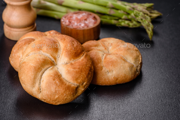 Crusty round bread rolls, known as Kaiser or Vienna rolls on a cutting ...
