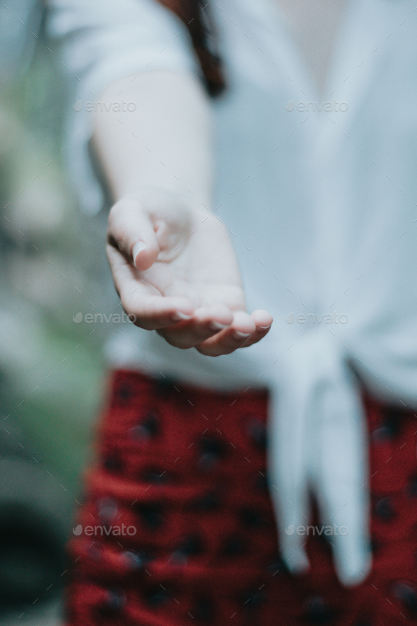 Woman giving one hand to the camera offering help on a natural parade ...