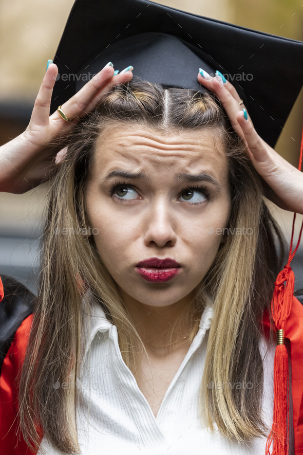 Close-up portrait of young lady wears graduation cap and looking aside ...