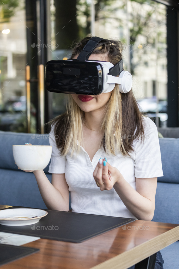 Vertical photo of young lady wearing VR set and drinking coffee Stock ...