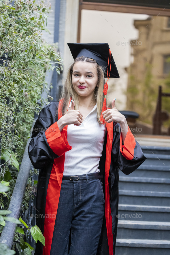 Vertical photo fo young lady wears graduation cape and smiling to the ...