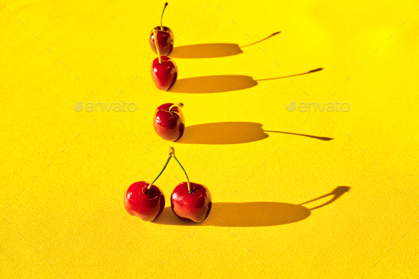 Top view of five red cherries with shadow isolated on a yellow ...
