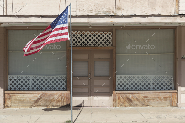American flag flying outside a building on a main street. Stock Photo ...