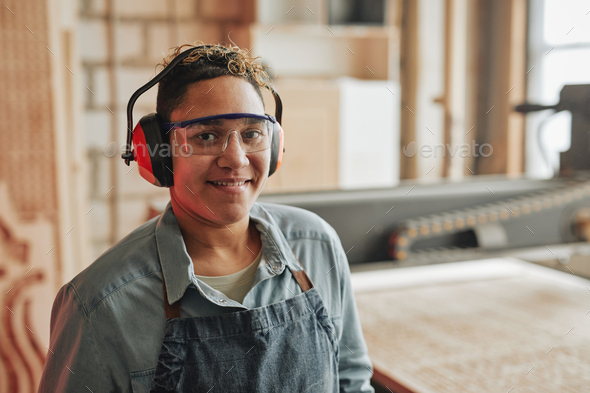 Smiling Female Worker Wearing Safety Gear in Shop Stock Photo by ...