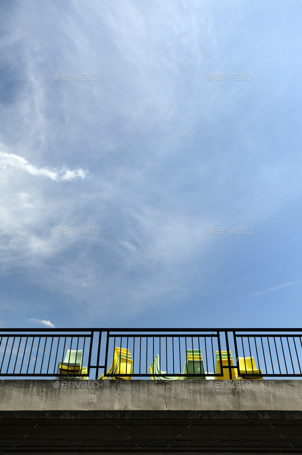 View from below of yellow and blue chairs on a terrace. Stock Photo by ...