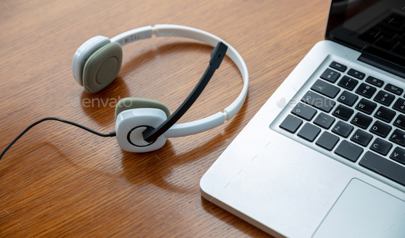 Home office, headset on a laptop, wooden table. Call center, customer ...