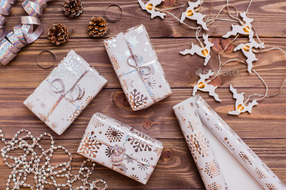 Wrapped in festive packaging gift boxes tied with silver ribbon, a roll ...