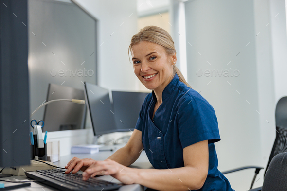 Nurse on Duty working on computer at the Reception Desk in modern ...