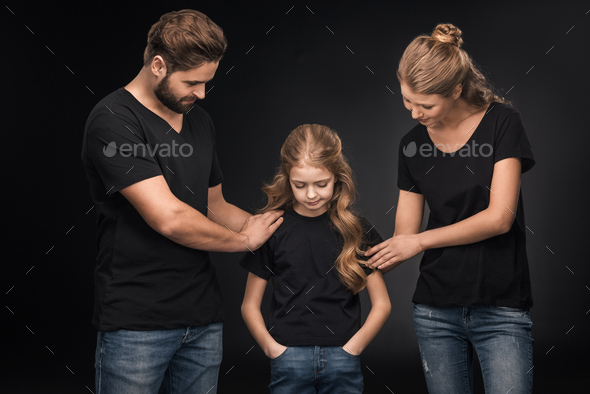 upset daughter and parents touching her and standing isolated on black ...