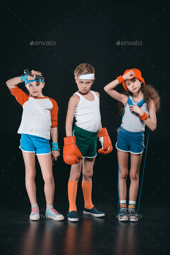 Three active kids in sportswear posing with sport equipment isolated on ...