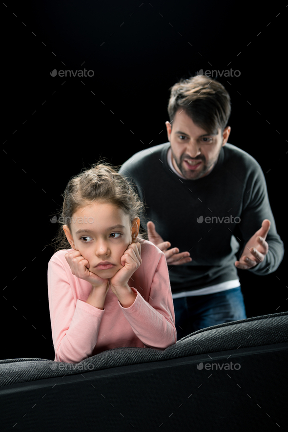Aggressive father screaming at upset daughter isolated on black, family ...